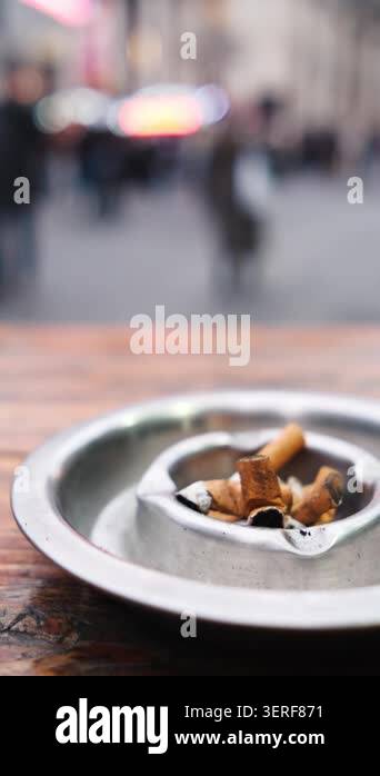 Full Cigarette Ashtray With Butts Sits On An Outdoor Cafe Table ...