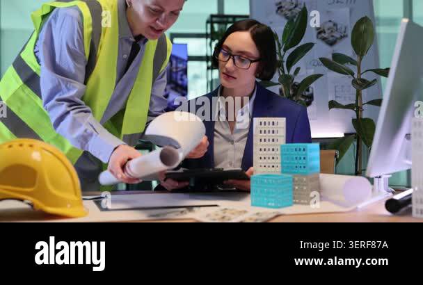 Builder shows construction drawings to professional architect ...