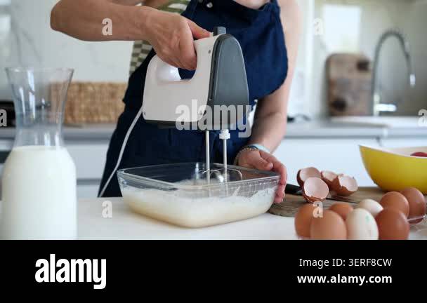 Girl Preparing Omelet Batter Using A Handheld Kitchen Mixer in Kitchen ...