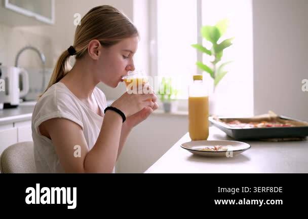 Cute Little Girl Drinks Orange Juice During Breakfast In Kitchen Stock ...