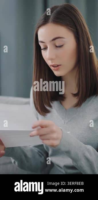 Woman sits in a living room reading a paper while showing different ...