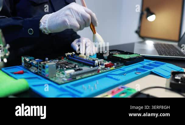 Technician in gloves repairing a hard drive with a screwdriver on a ...