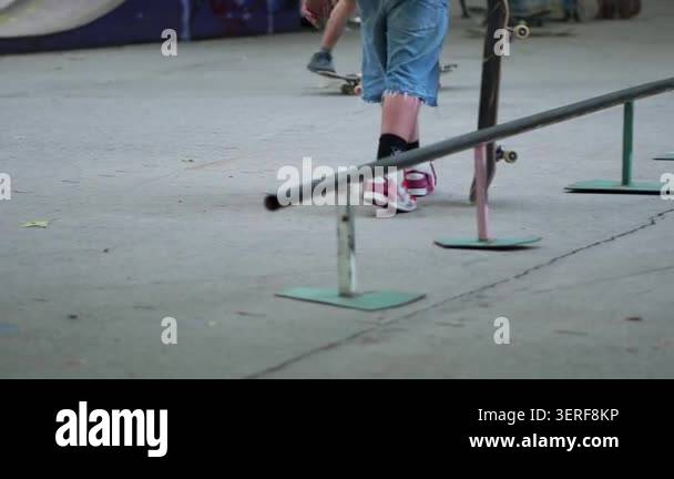 Young skater attempting a complex trick on a skateboard, losing balance ...