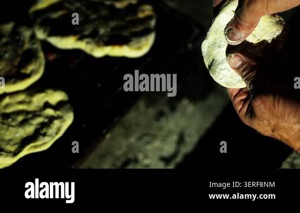 Close up view of weathered hands kneading and stretching dough with ...