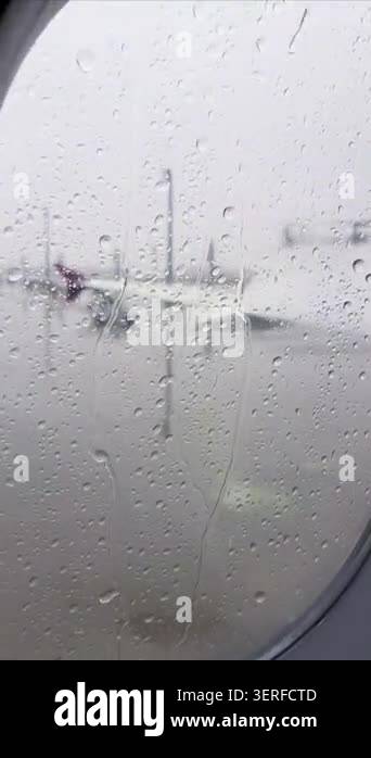 Passenger view through aircraft window as ground crew performs aircraft ...