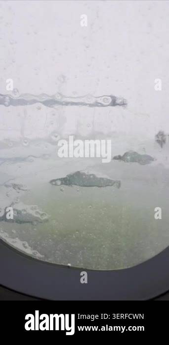 Passenger view through aircraft window as ground crew performs aircraft ...