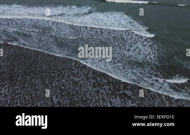 Aerial drone footage captures the rhythmic movement of ocean waves ...