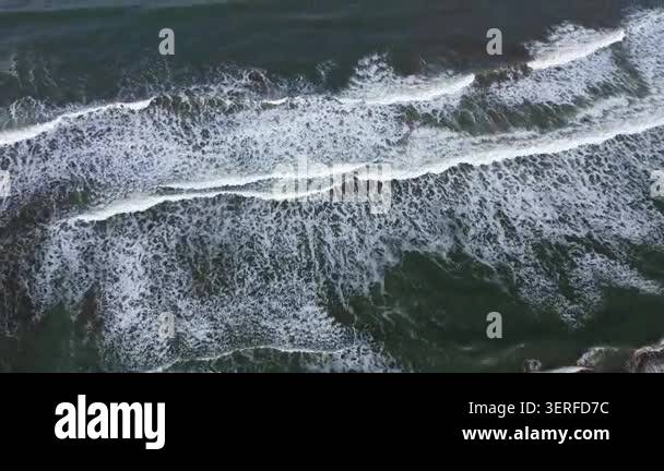 Aerial view of ocean waves crashing on the shore, showing white foam ...