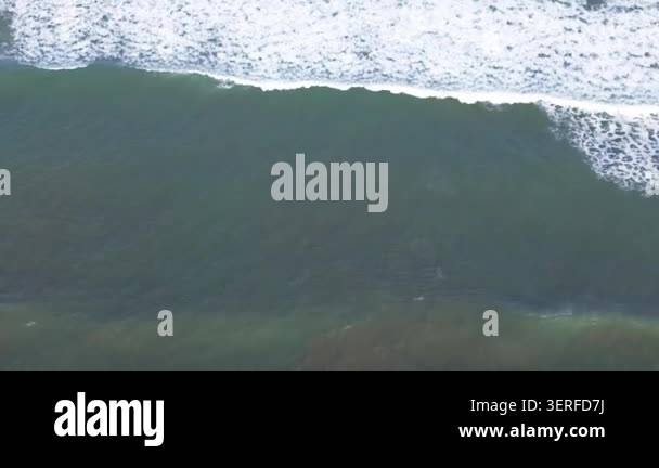Aerial view of ocean waves crashing on the shore, showing the vast ...