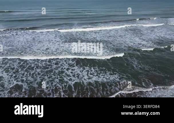 Aerial drone footage captures the rhythmic motion of ocean waves ...