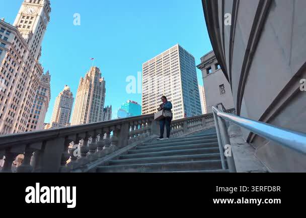 Chicago, USA, 7 May 2026: Woman checking phone on bridge staircase ...