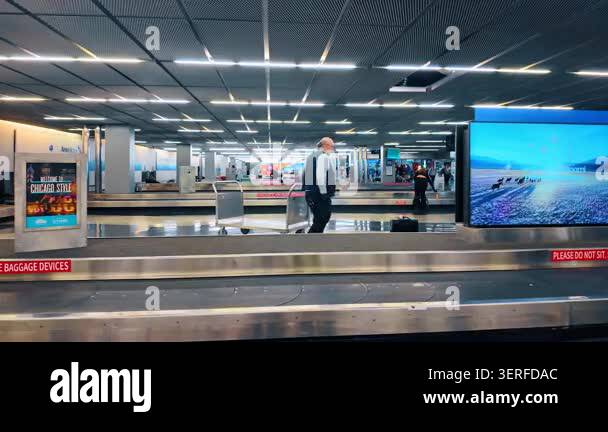 Chicago, USA, 7 May 2026: Man with luggage cart at empty baggage ...