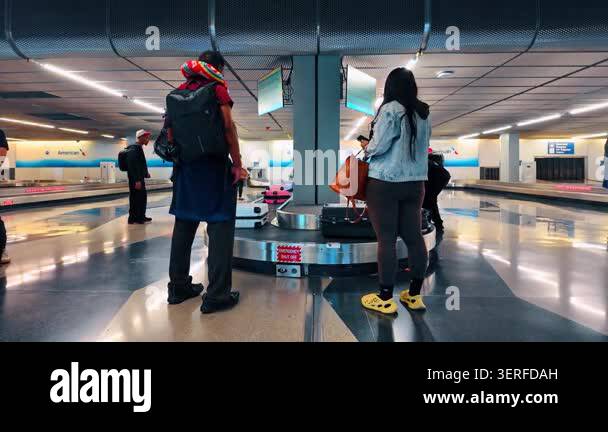 Chicago, USA, 7 May 2026: Travelers waiting at baggage claim carousel ...