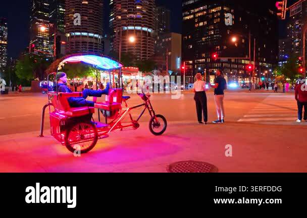 Chicago, USA, 7 May 2026: Night view of a neon lit pedicab on a street ...