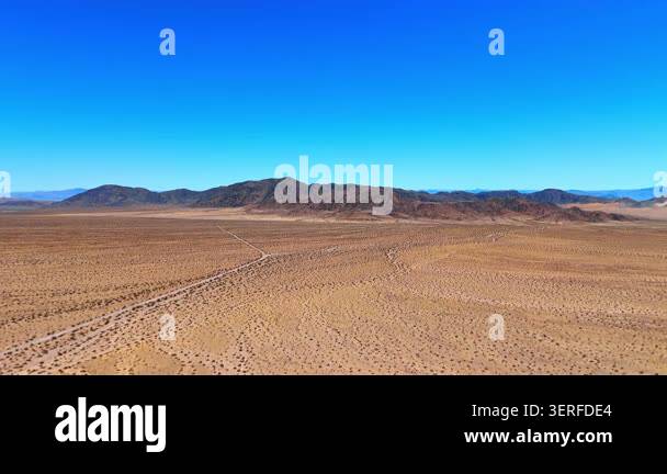 Ground road in the vast hot desert. Rocks with no greenery on in the ...