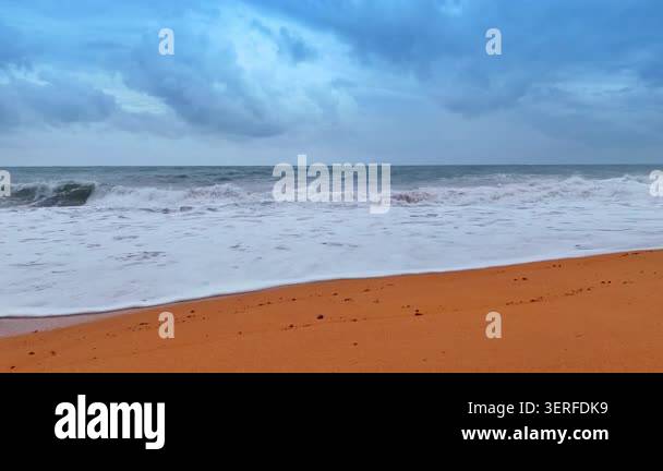 Orange sand beach with crashing waves under stormy sky, Panama. Ground ...