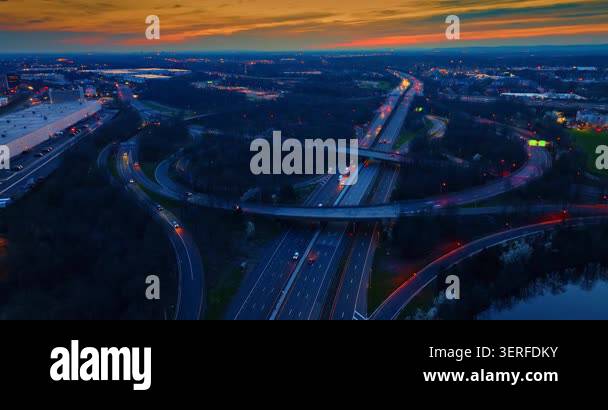 Sunset sky over a curved highway cloverleaf ramp, United States ...
