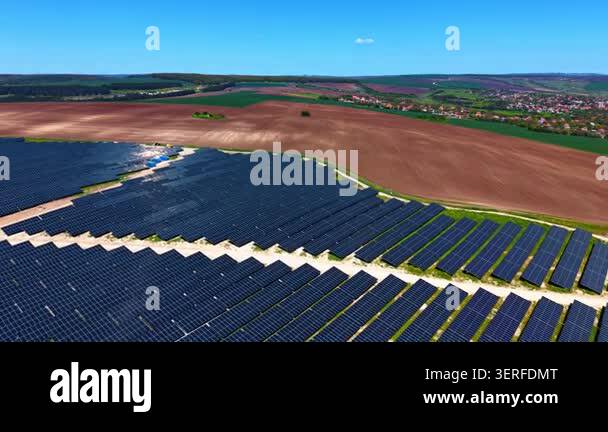 Solar power plant adjacent to farmland and rural village. Aerial view ...