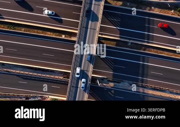 Vehicles crossing a road bridge over a highway in Spain. Close overhead ...