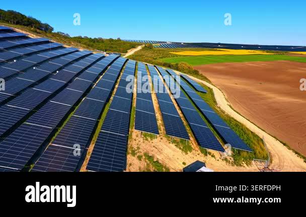 Aerial view of solar farm bordered by plowed and rapeseed fields. Drone ...