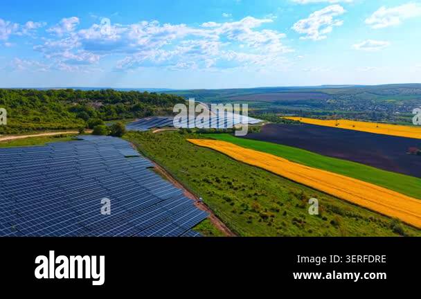 Aerial view of solar farm beside rapeseed fields in rural countryside ...