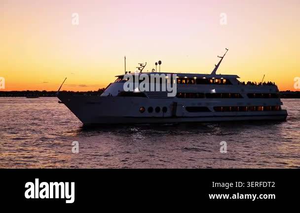 New York, USA, 8 May 2026: Cruise boat silhouette at sunset, New York ...