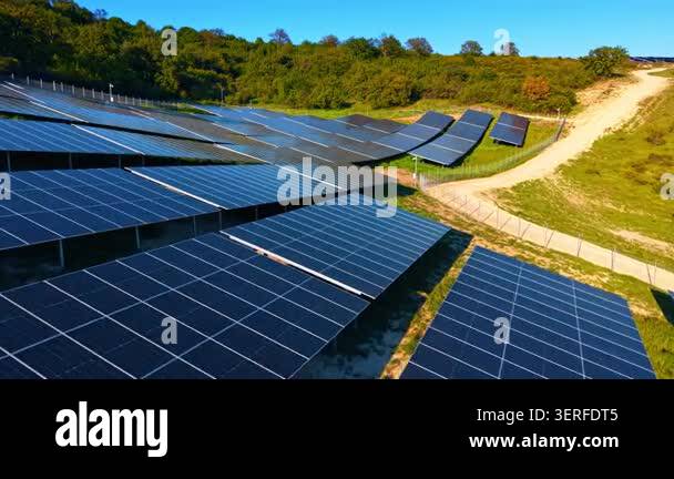 Ground mounted solar arrays near wooded hillside with dirt road ...