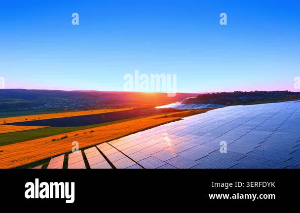 Sunset light over solar panel farm in rural countryside. Diagonal rows ...