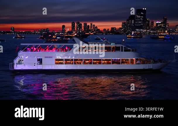 New York, USA, 8 May 2026: Illuminated party yacht cruising at night on ...