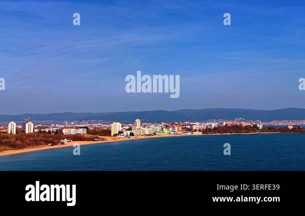 Coastal resort town with sandy beach along calm sea. Elevated panoramic ...
