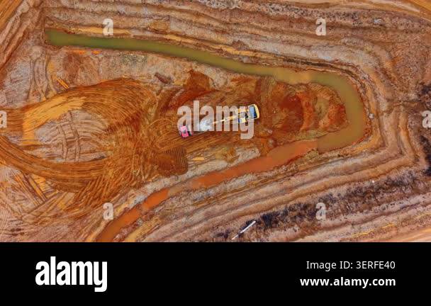 Overhead view of excavator digging in sand quarry. Top down drone shot ...
