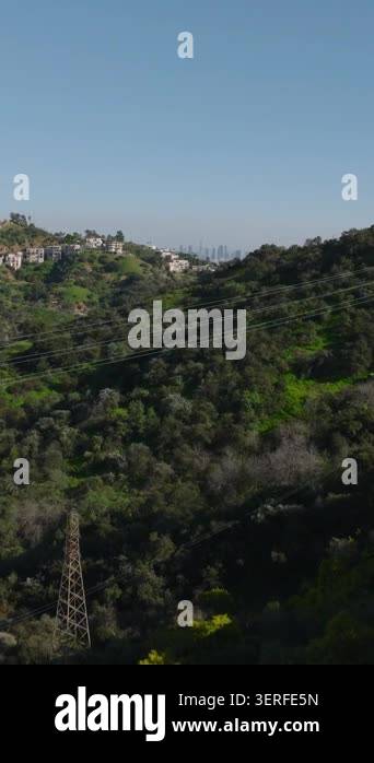 Fly over wooded hilly landscape. Revealing houses in valley and ...