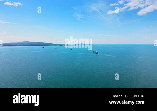 Freighters navigating turquoise waters near forested cape, Bulgaria ...
