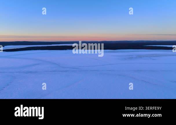 Frozen lake at twilight with snow covered landscape, Lapland. Wide ...