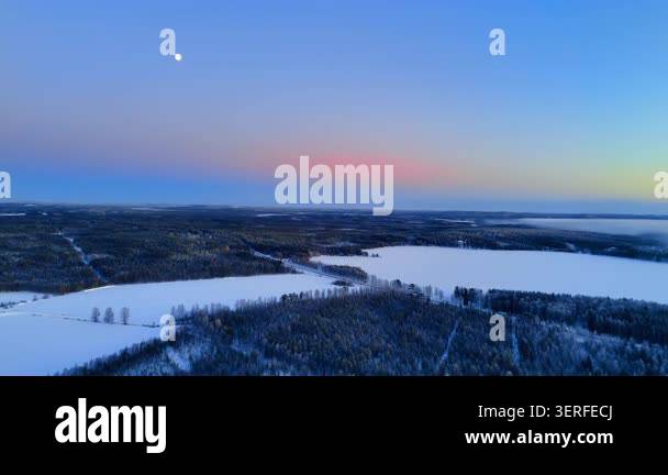 Moonrise over frozen fields and forests, Finnish Lapland. Aerial winter ...