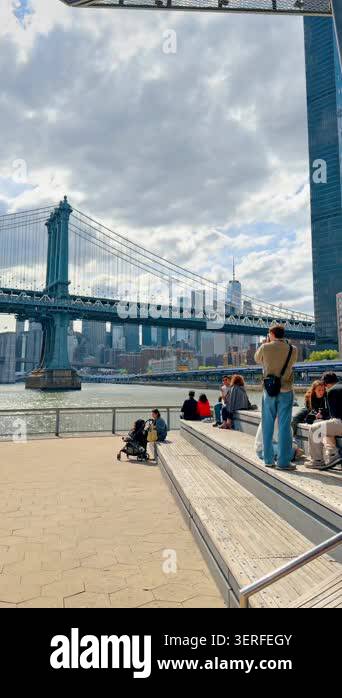 New York, USA, 22 May 2026: People relaxing at Brooklyn Bridge Park ...