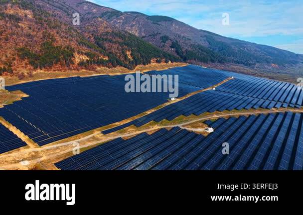 Photovoltaic power station at the base of forested mountain slope ...