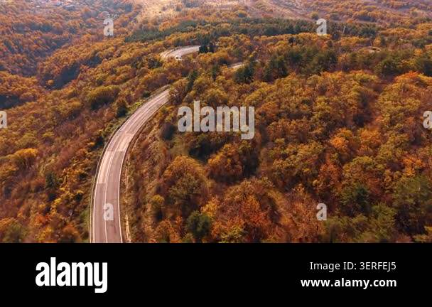 Hairpin bends on mountain road through autumn woodland. Switchback ...