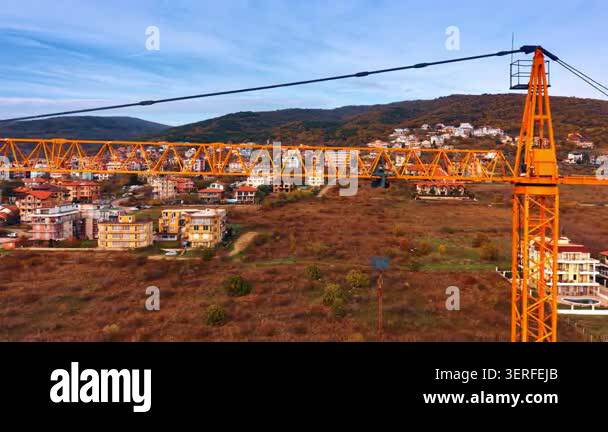 Tower crane over residential area with hillside town, Bulgaria. Drone ...