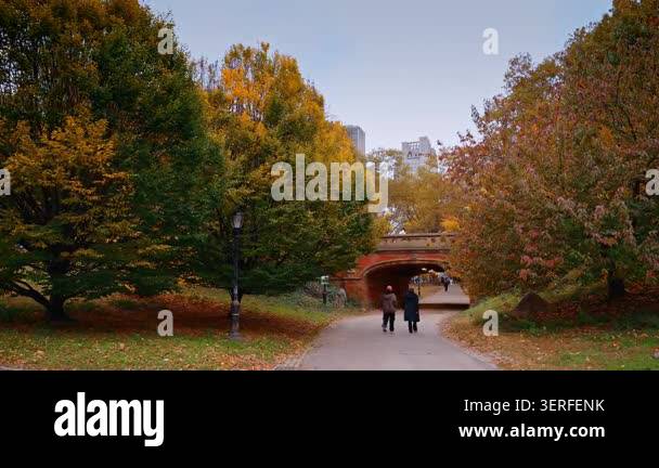New York, USA, 25 October 2025: Two pedestrians walking toward a brick ...