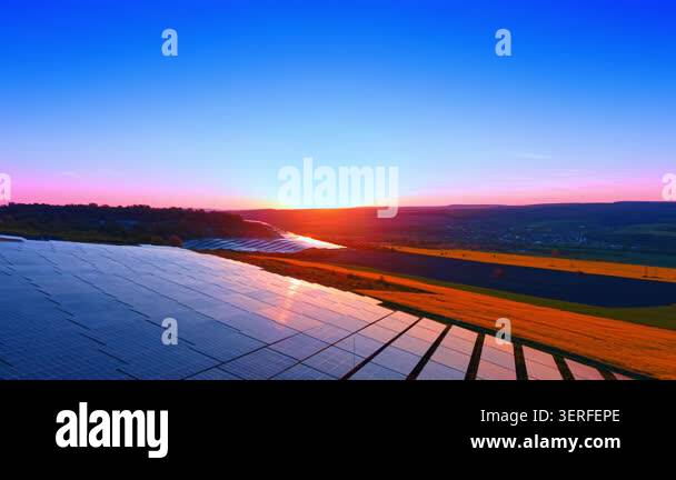 Setting sun light covering the scenery and filed of solar panels. Green ...