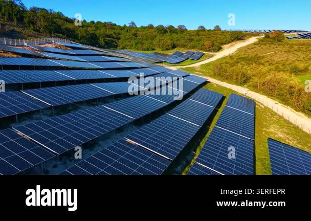 Hill covered with big modern solar panels. Green countryside area used ...
