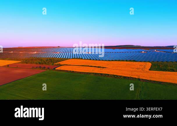 Colorful fields surround the course of solar panels. Drone footage ...