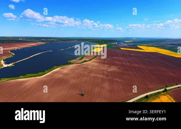 Solar farm amid agricultural patchwork landscape. Panel arrays beside ...