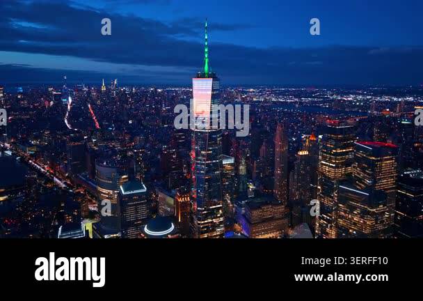 Colorful spire of One World Trade Center above Manhattan at night ...