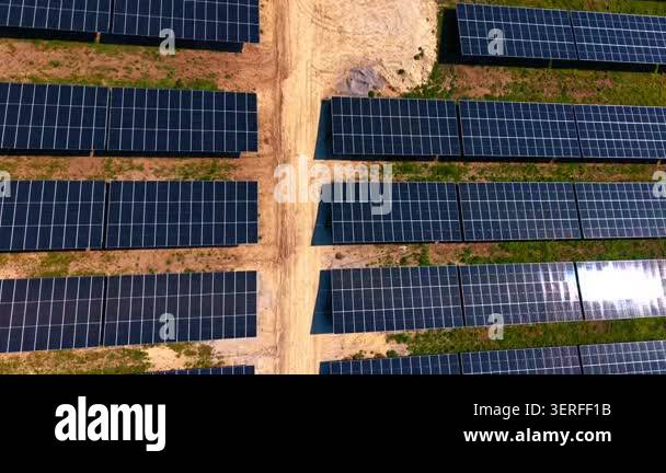 Solar panel rows divided by dirt path. Symmetrical dark modules ...