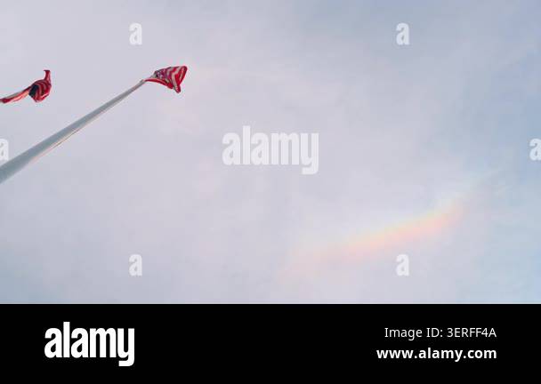 Poles with American flags flapping in the wind. Low angle view ...
