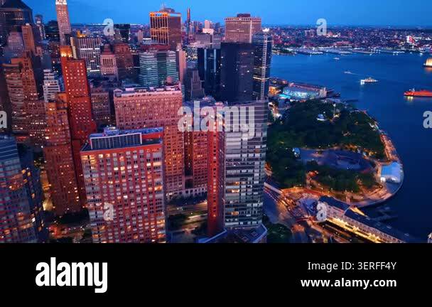 New York City switches on lights at dusk time. Cruise boats move by the ...