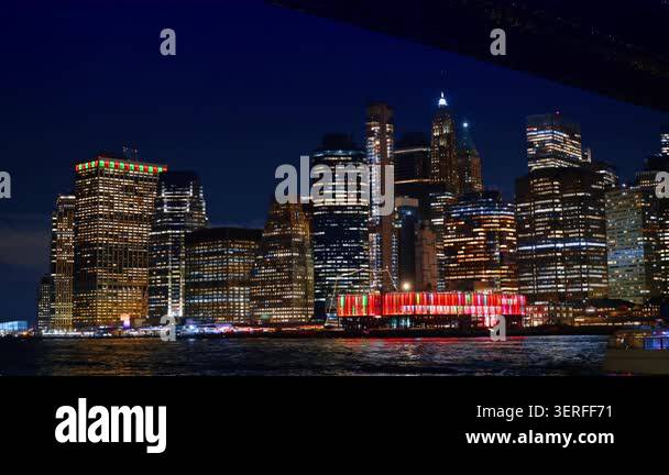 Lower Manhattan skyline from the East River at night. Colorful pier ...