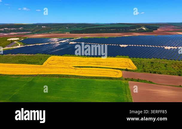 Elevated view of solar power plant beside rapeseed fields in spring ...